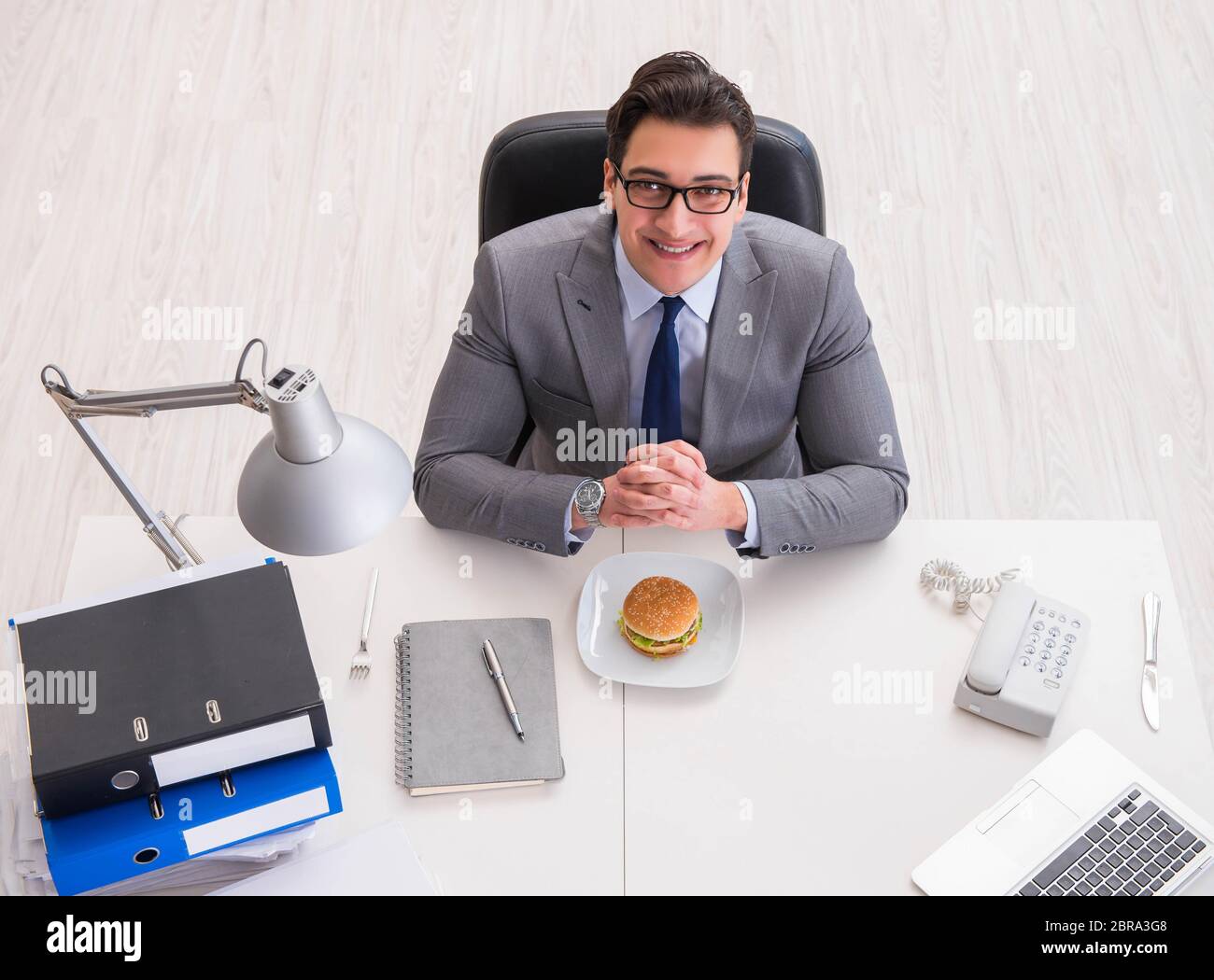 The hungry funny businessman eating junk food sandwich Stock Photo - Alamy