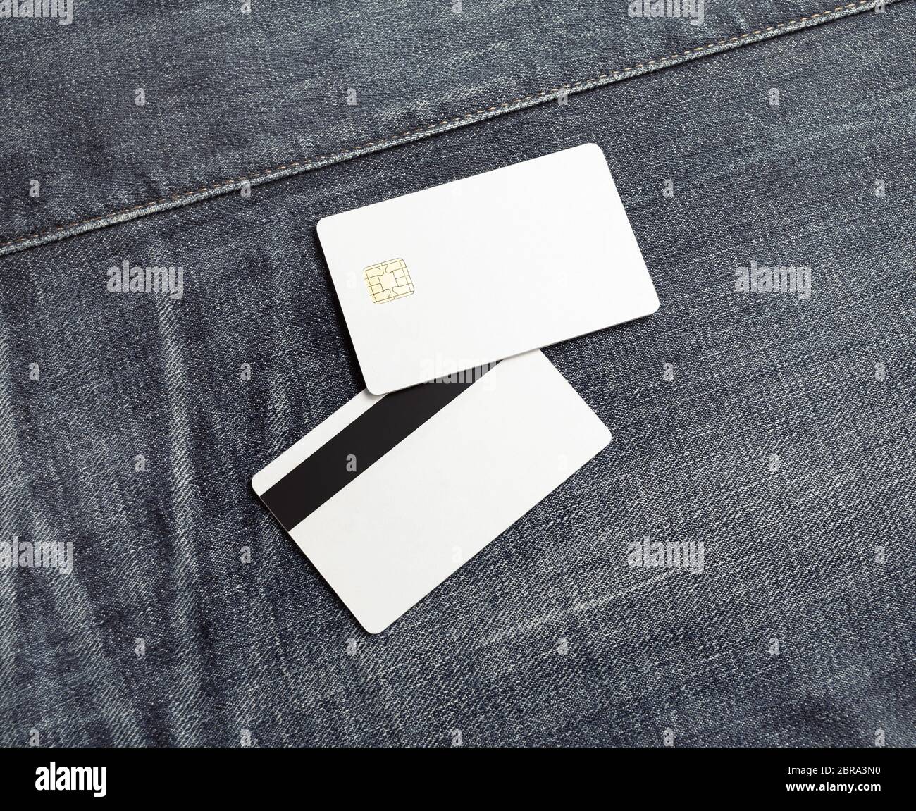 Photo of blank white plastic credit cards on denim background. Two bank ...