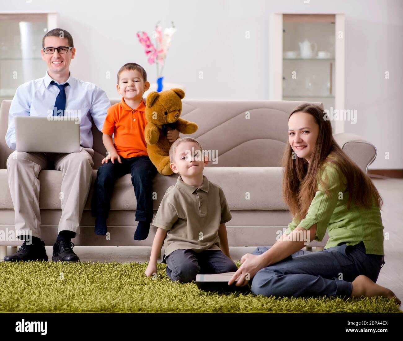 The father is trying to work while children are playing Stock Photo - Alamy