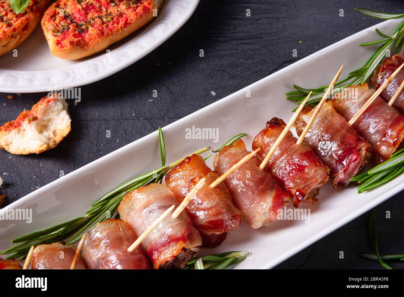 dates wrapped in bacon and delicious tapas Stock Photo - Alamy