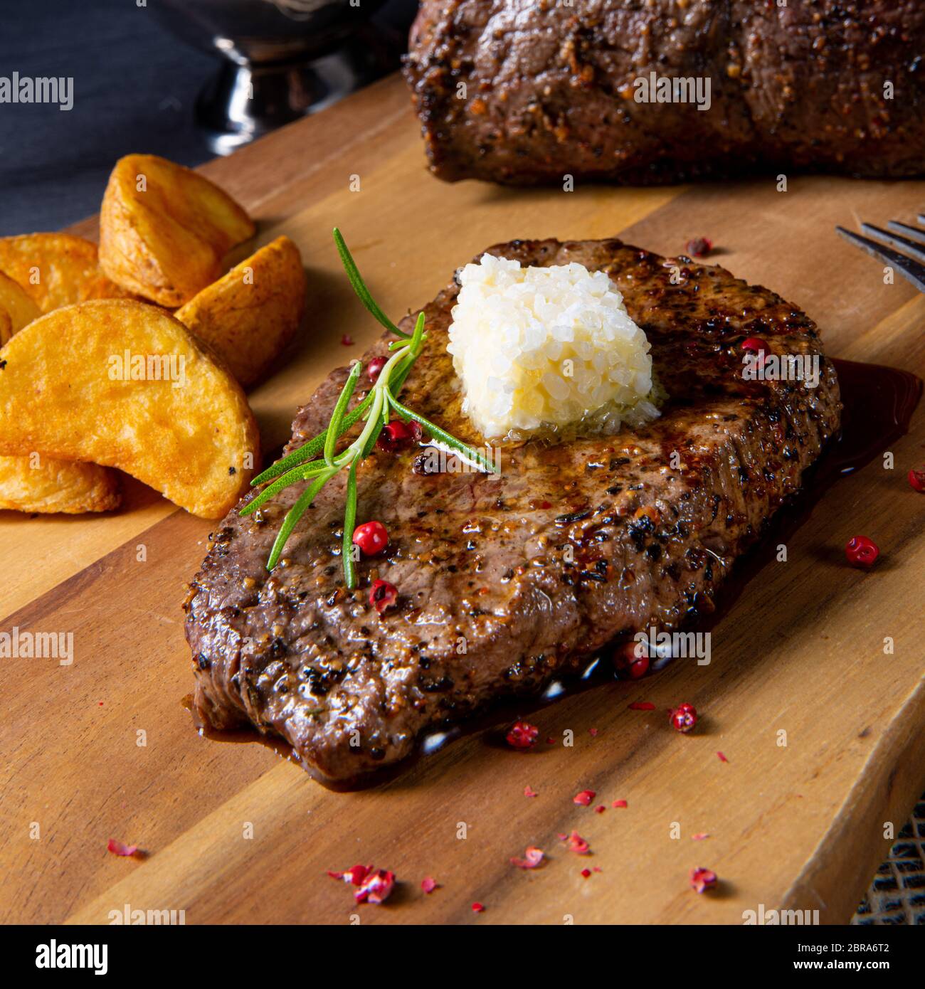 Butter Beef Steak with herbs and potato wedges Stock Photo - Alamy