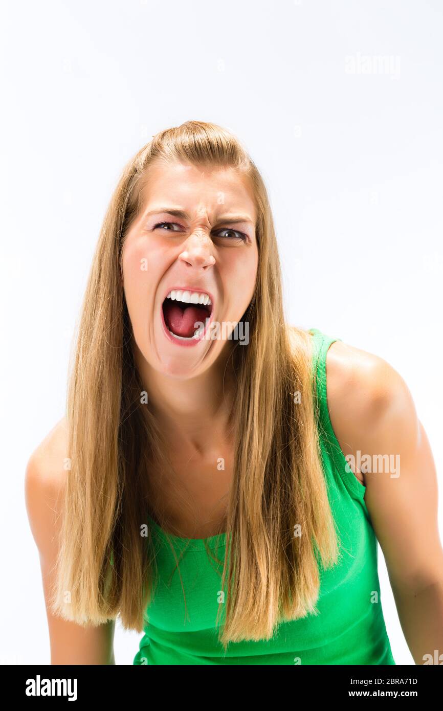 Portrait of blonde young woman screaming against white background Stock ...