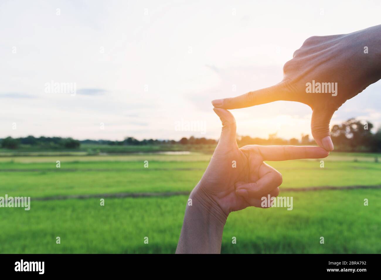Hands making frame with sunset. Close up of woman hands making frame ...