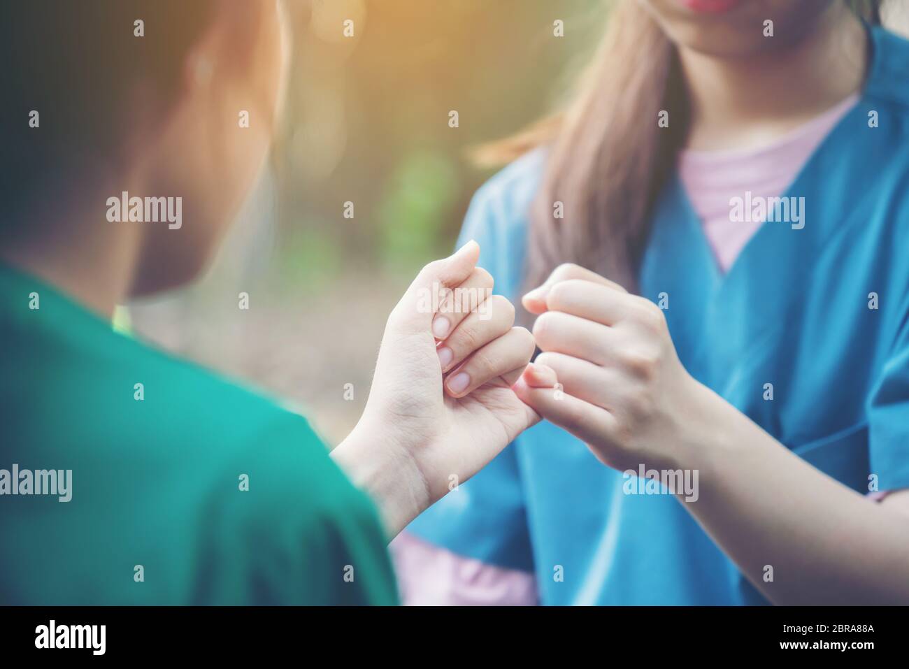 hands hook each other's little finger on nature background, concept of ...