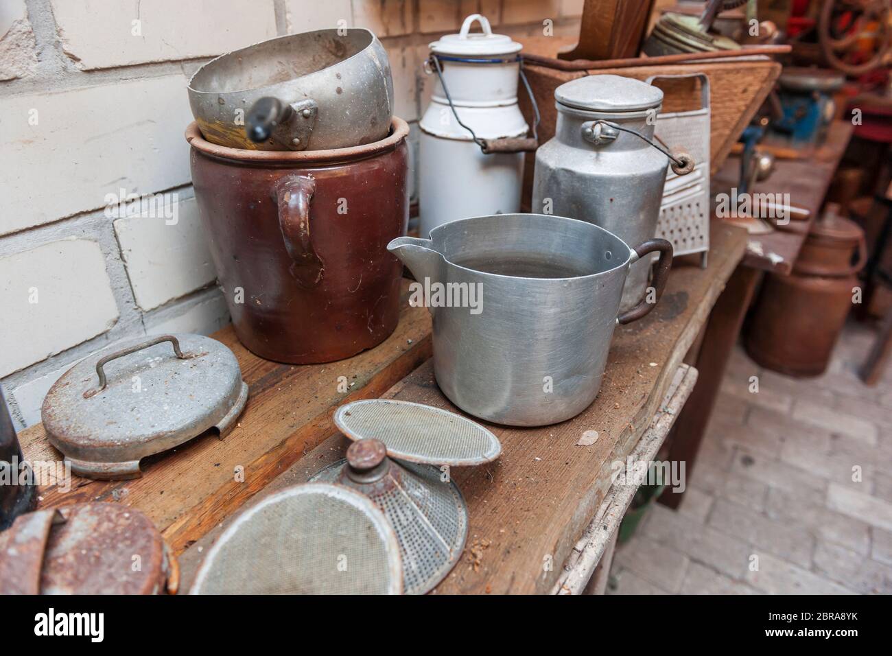 Old stone pot and tin cans on a raw stone wall Stock Photo - Alamy