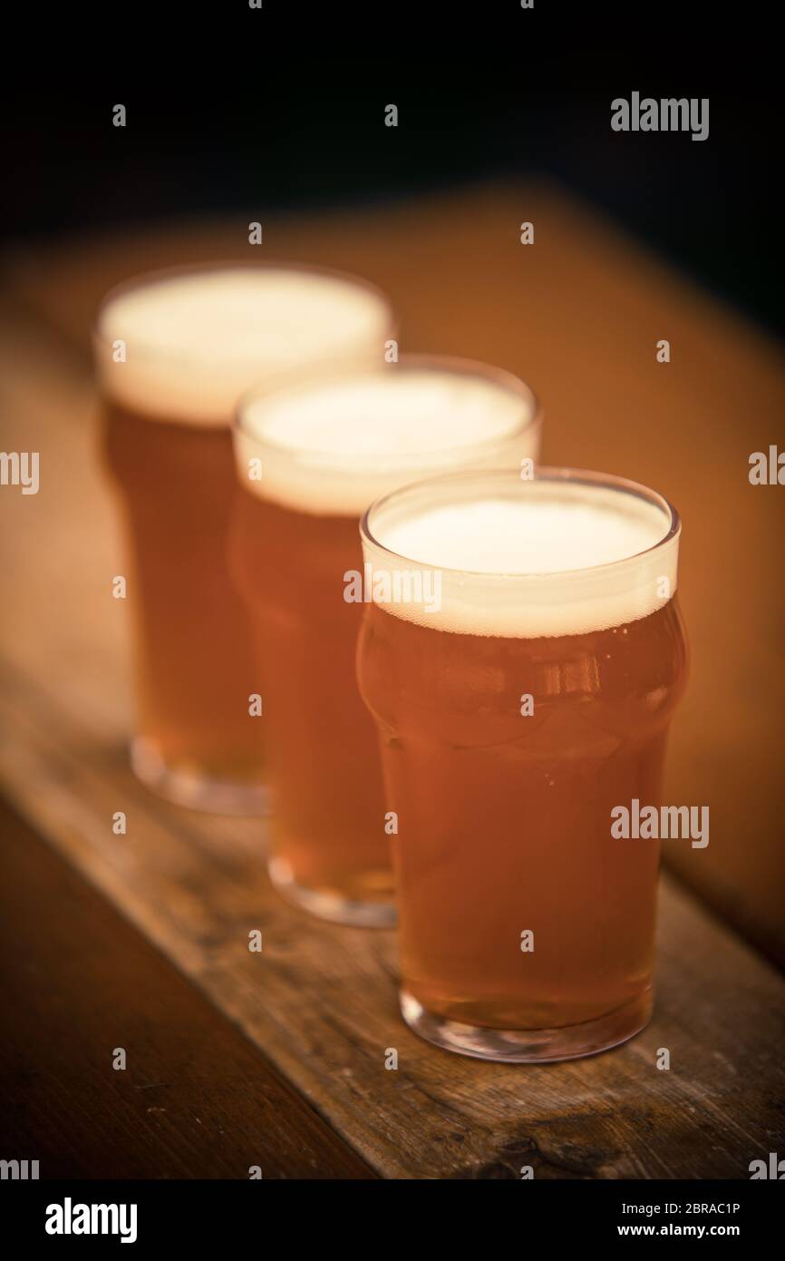 Three pints of beer in a row, on a table Stock Photo - Alamy