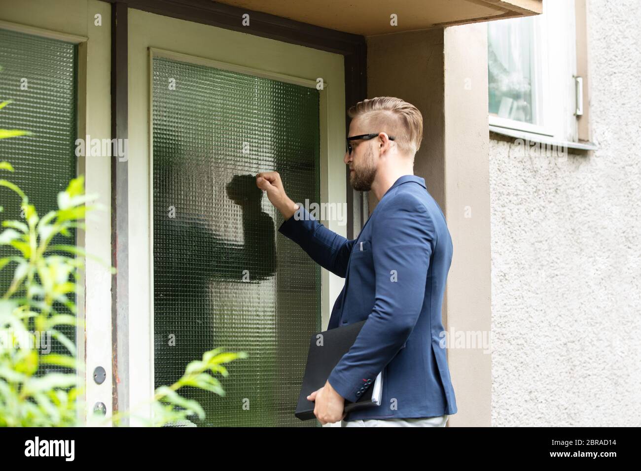 Man Standing At The Entrance Of The House Knocking The Door Stock Photo ...