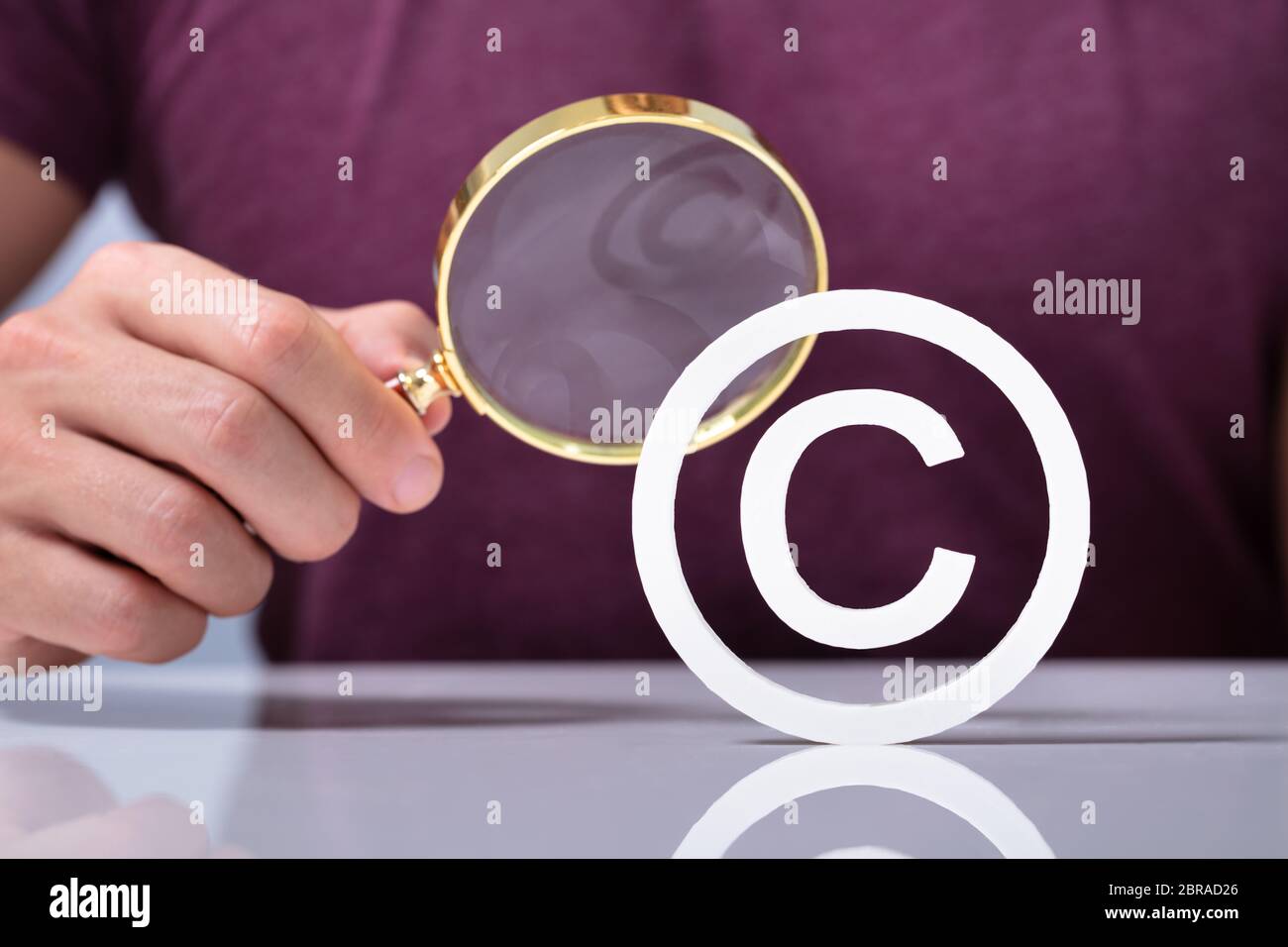 A Person's Hand Holding Magnifying Glass Looking Copyright Symbol Icon ...