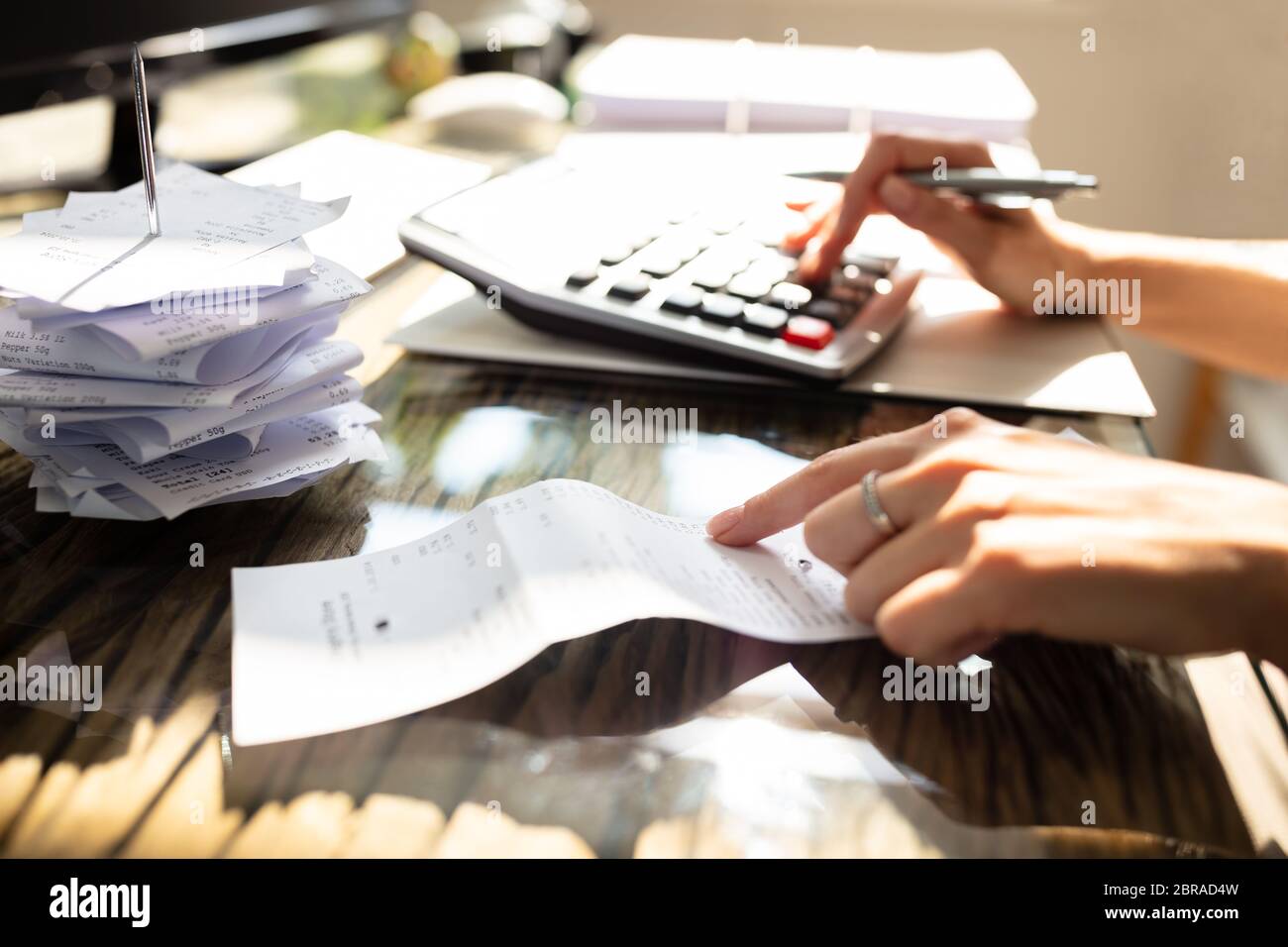Close-up Of A Businesswoman Checking Bill Over Wooden Desk In Office ...