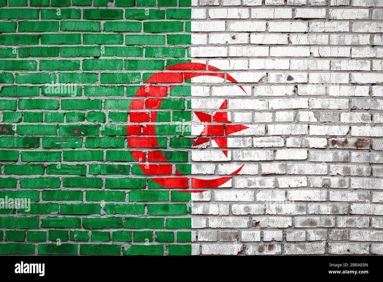 National flag of Algeria depicting in paint colors on an old brick wall ...