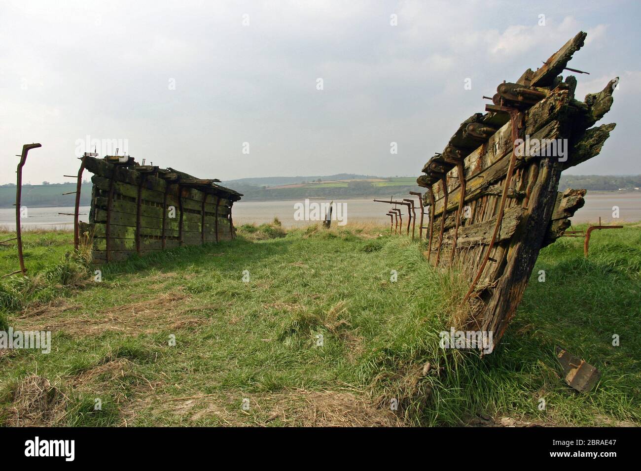 Both sides of a derelict abandoned wooden barge rotting alongside a ...