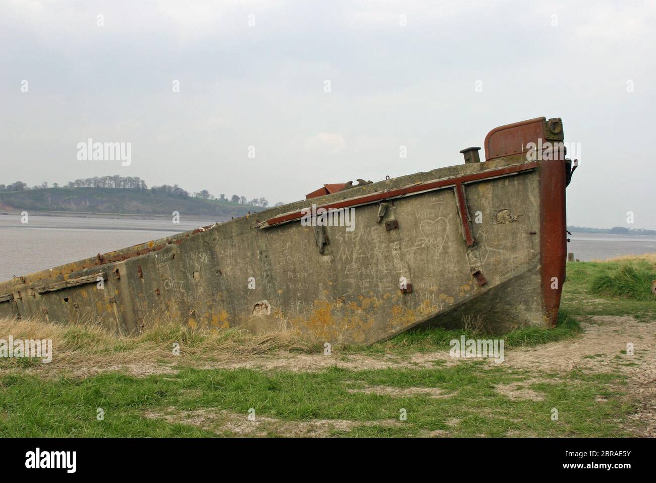 One side (starboard) of a derelict abandoned unusual concrete barge ...