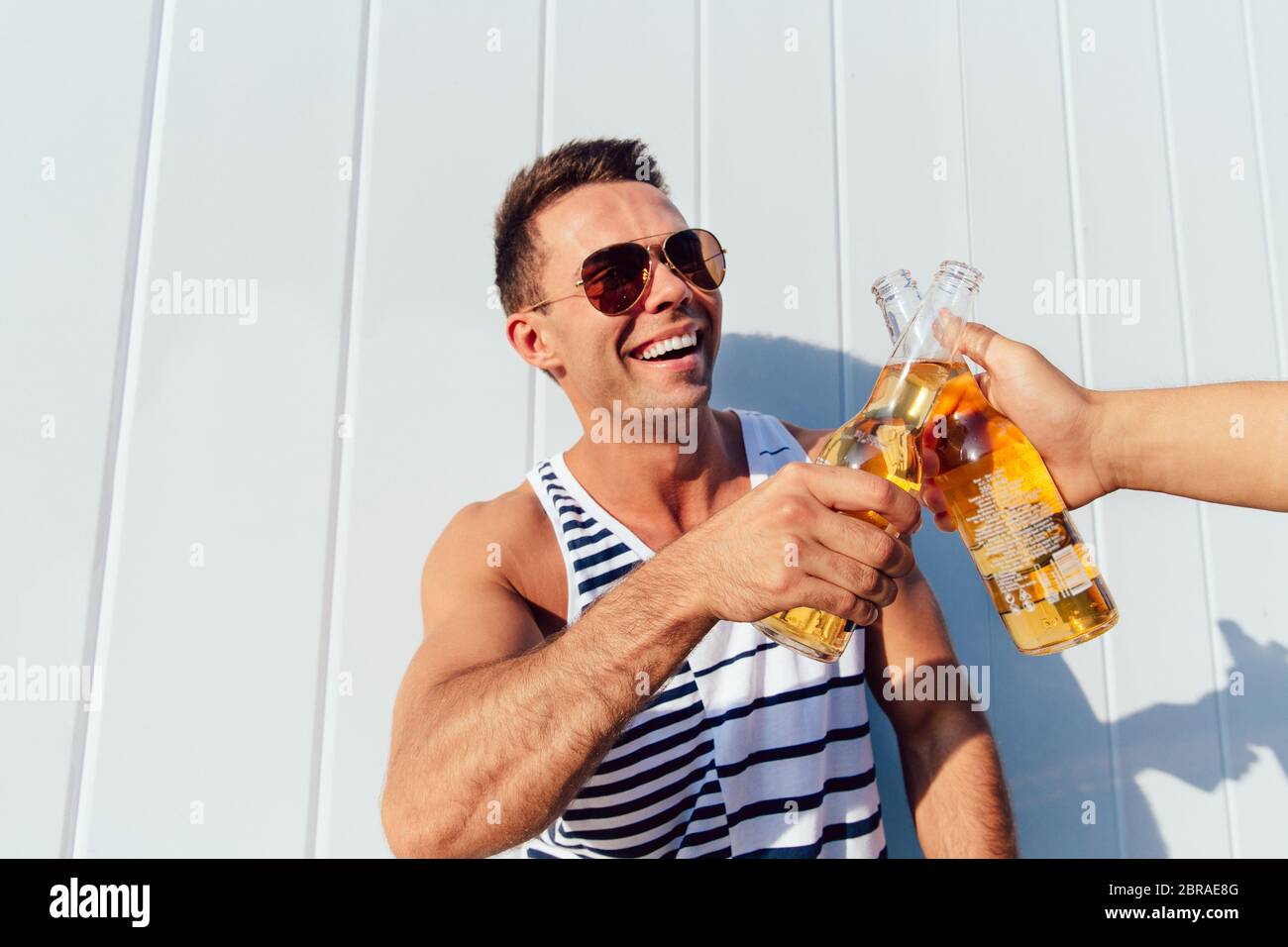 Cheerful smiling man making a toast with beer, standing opposite the ...