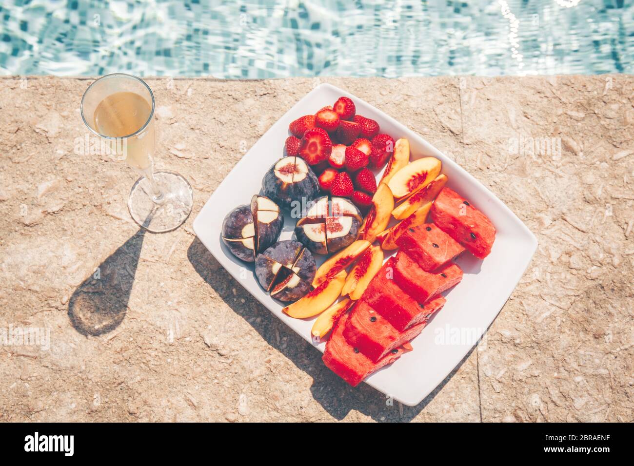 Exotic tropical fruit plate on the pool edge. Healthy treat, luxury ...