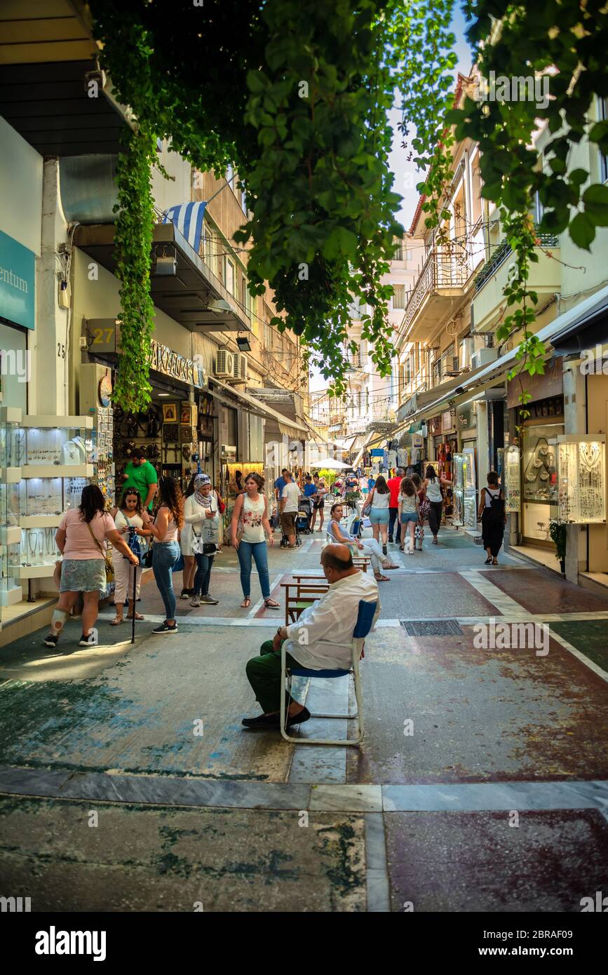 Tourists and local Greeks shop at the outdoor shopping center and ...