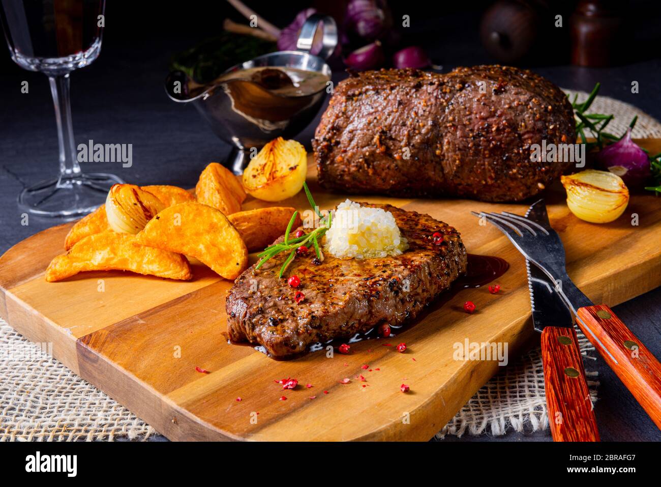 Butter Beef Steak with herbs and potato wedges Stock Photo - Alamy