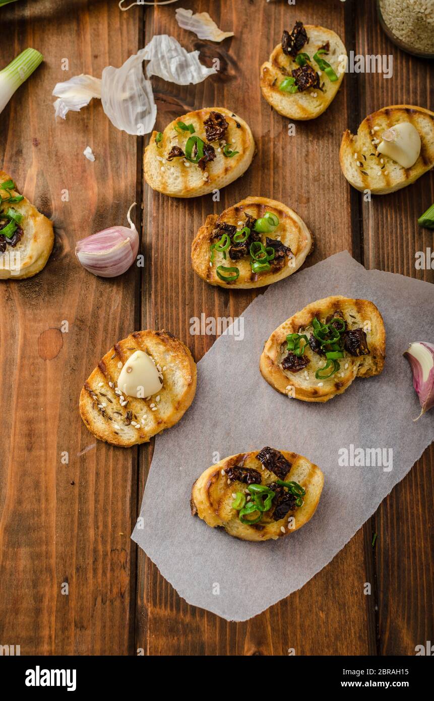 Mini toasts with garlic and dried tomato, sprinkled with herbs Stock ...