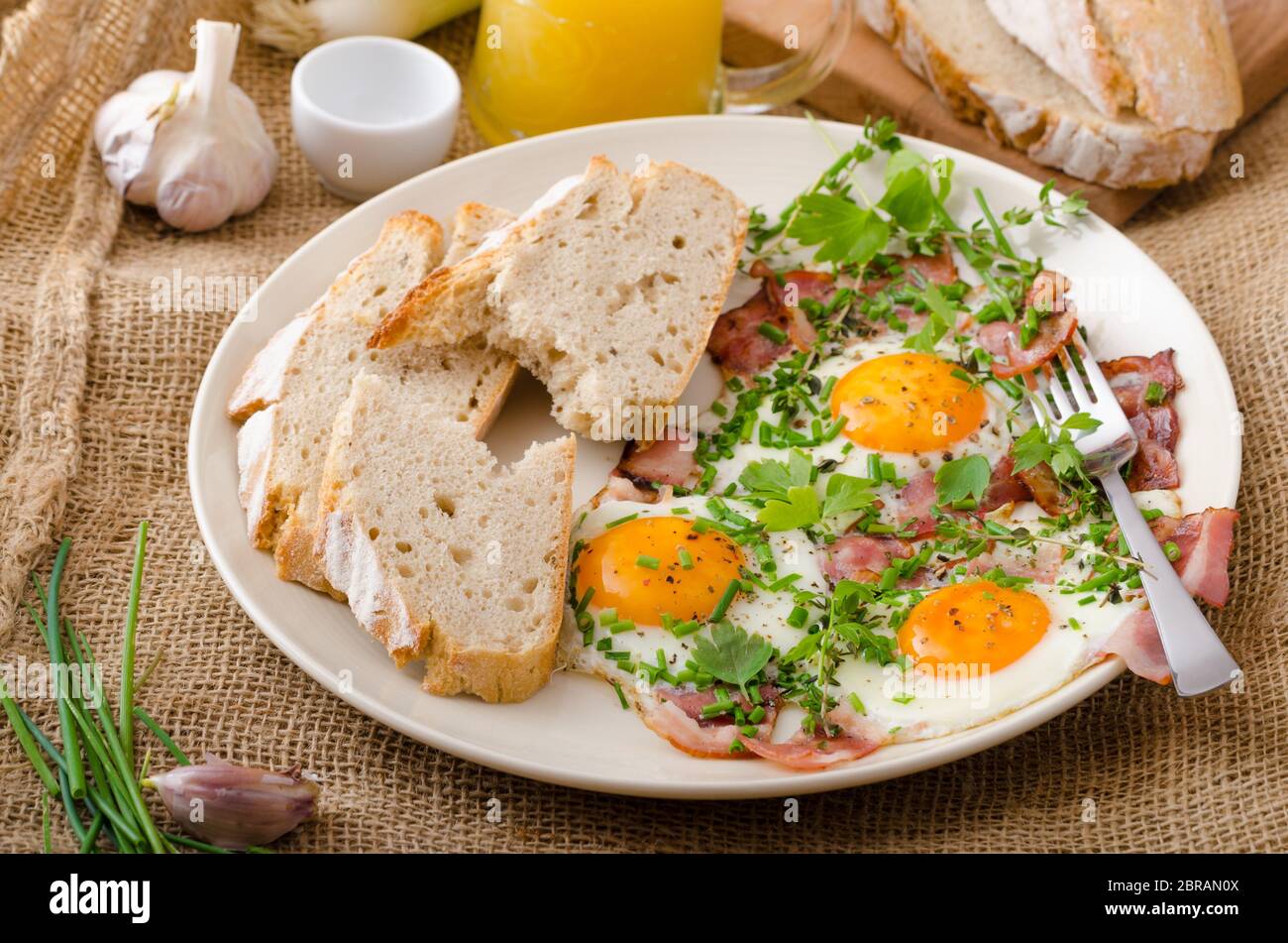Spring omelette with bacon, egg and herbs, homemade rustical bread ...