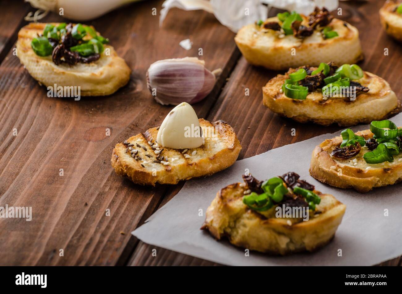 Mini toasts with garlic and dried tomato, sprinkled with herbs Stock ...