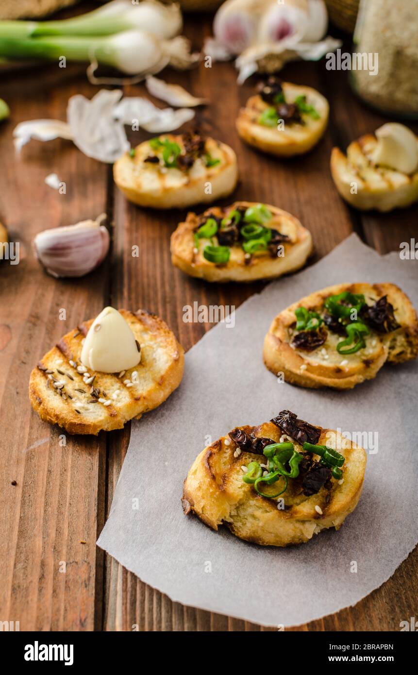 Mini toasts with garlic and dried tomato, sprinkled with herbs Stock ...