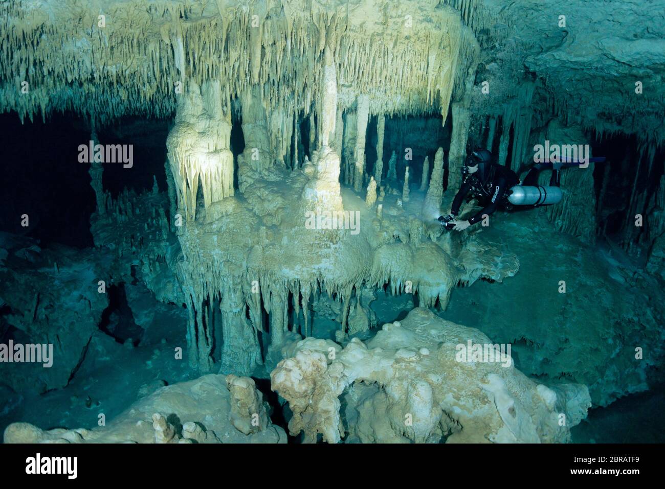 Sidemount technical diver swimming around unique limestone formations ...