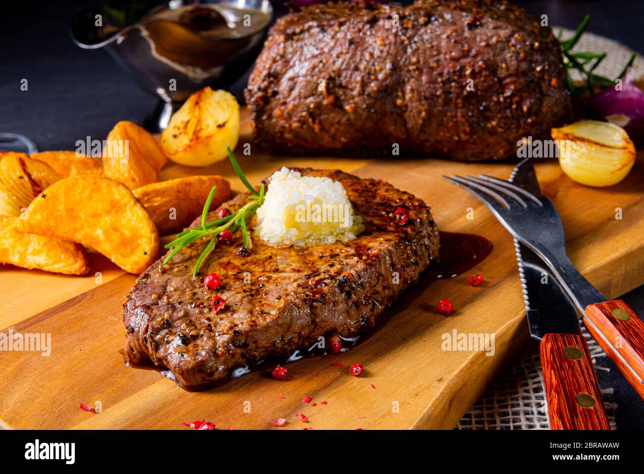 Butter Beef Steak with herbs and potato wedges Stock Photo - Alamy