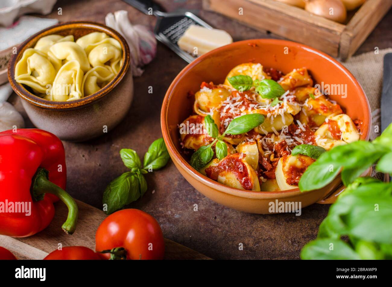 Homemade tortellini with tomato sauce, herbs and garlic in, topped with parmesan cheese Stock ...