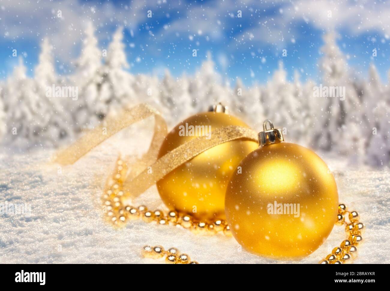 Golden baubles as Christmas decoration and landscape in the background ...