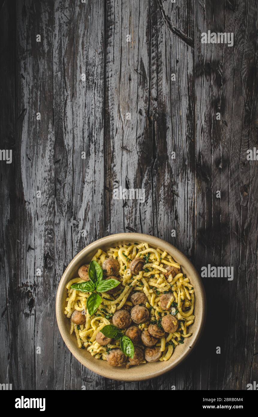 Homemade spaetzle, barbecue sausage and fresh cheese, herbs on rustic ...