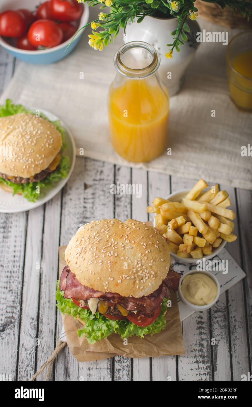 Homemade bacon burger with lettuce and cheddar, homemade potato french ...