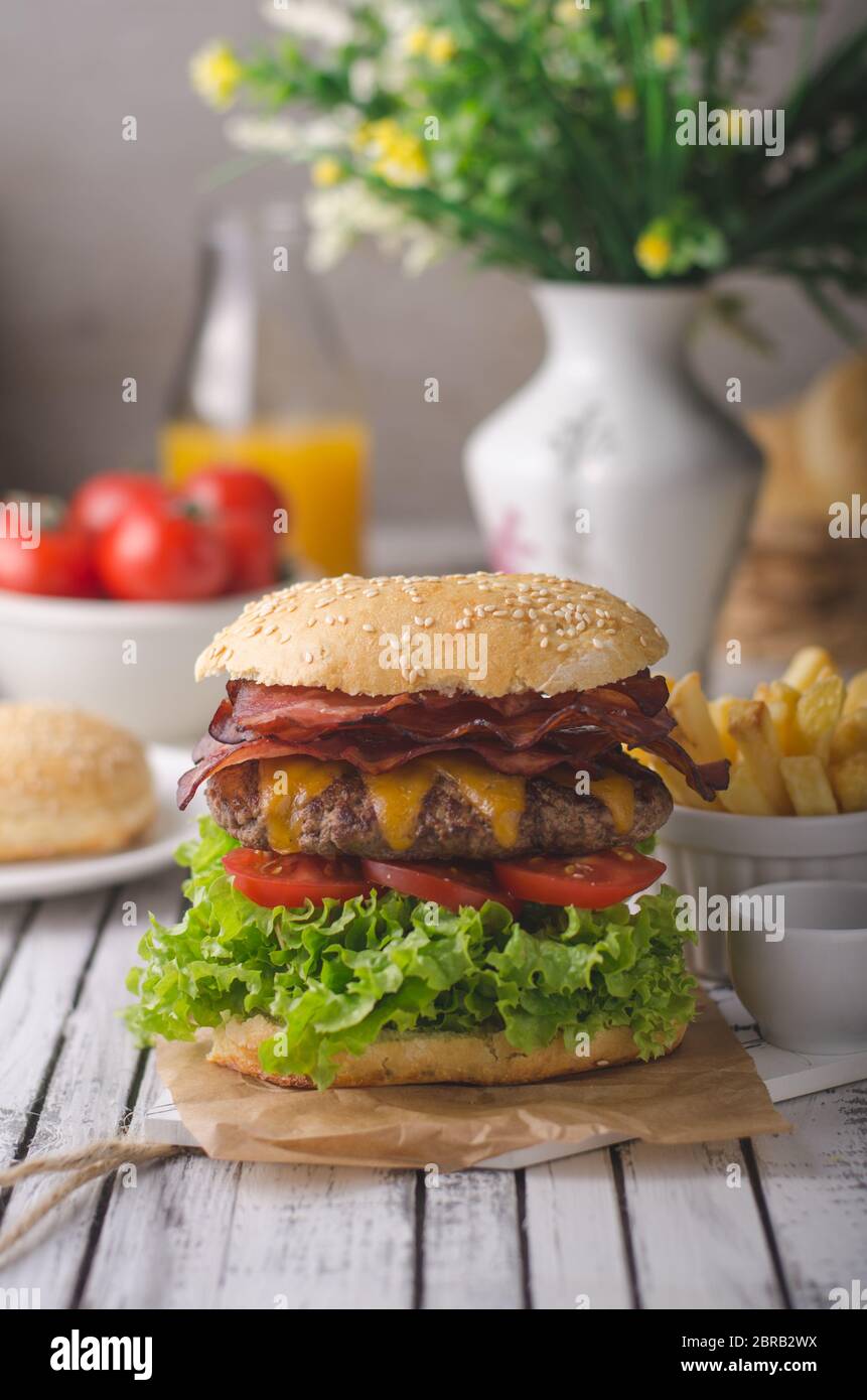 Homemade bacon burger with lettuce and cheddar, homemade potato french ...