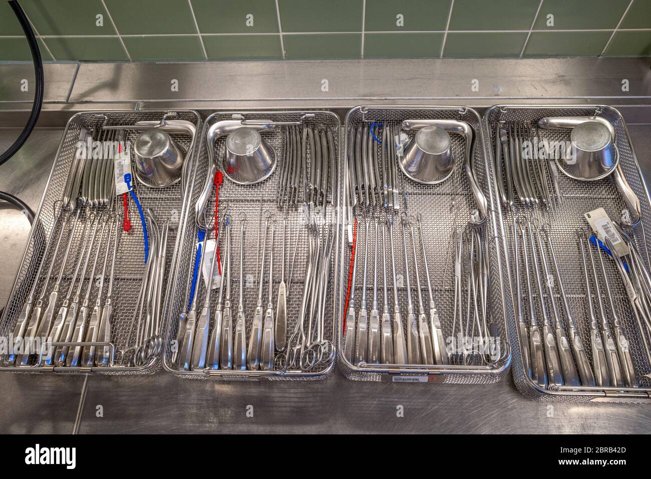 a sterilization department has four cleaned and sorted instrument trays ...