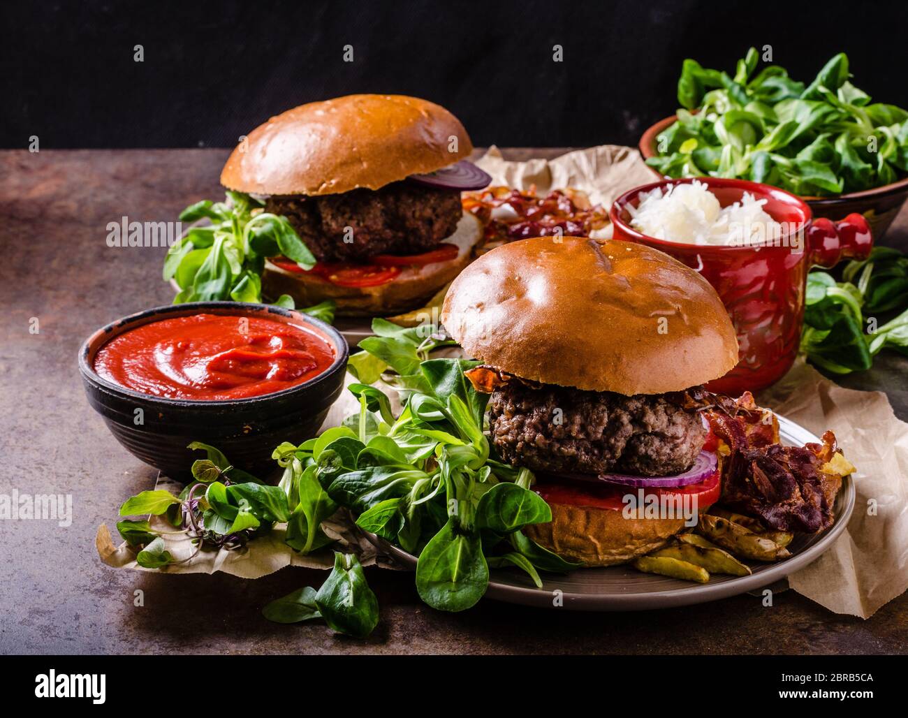Beef burger with bacon and home french fries, little salad and hot ...