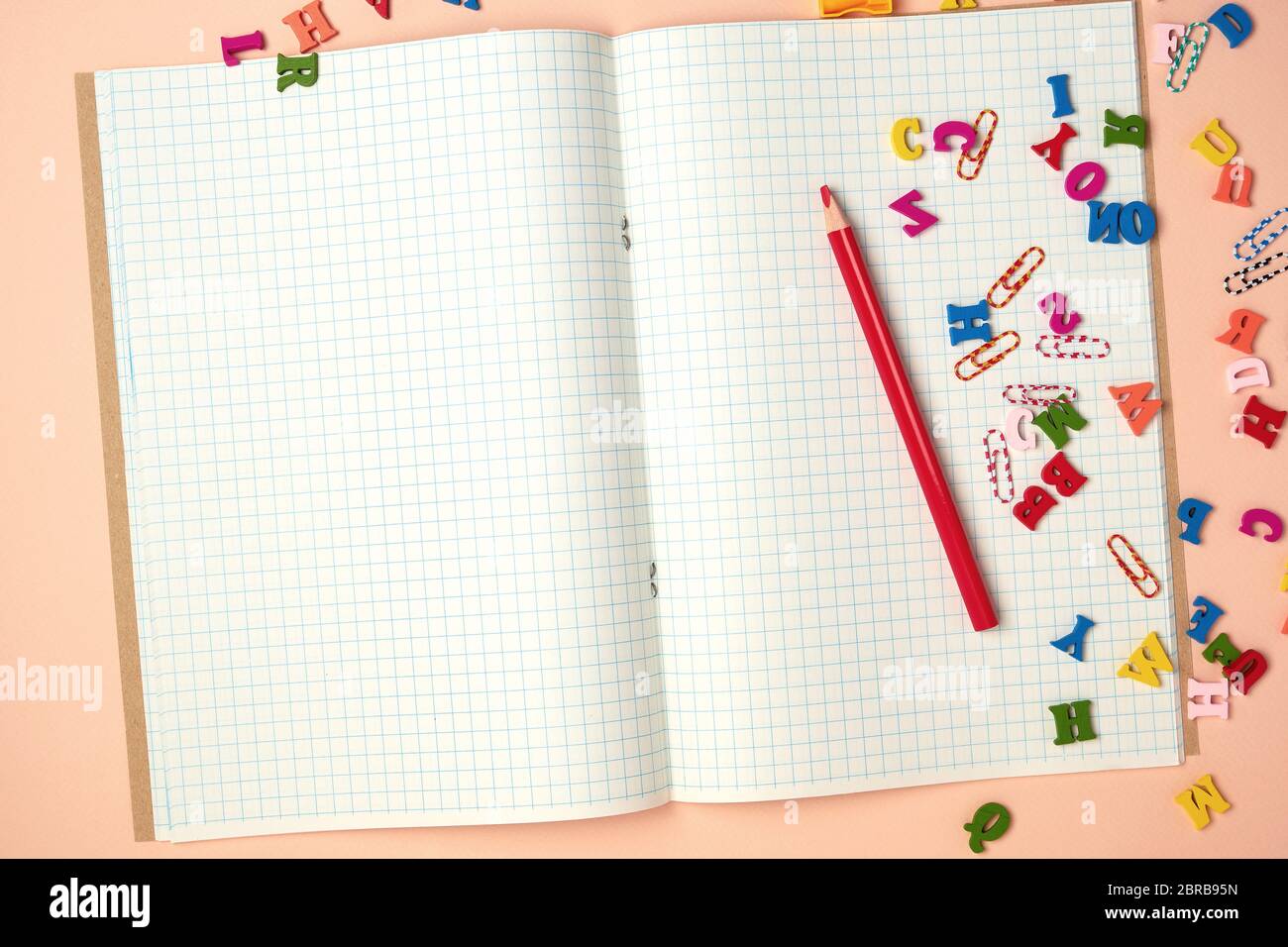 open checked notebook and red wooden pencil, back to school backdrop ...