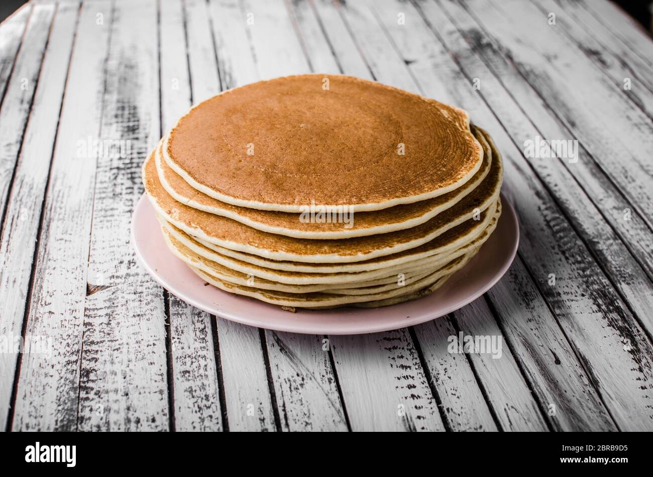 Homemade crepes with frozen berries, topped sugar, rustic wood board ...