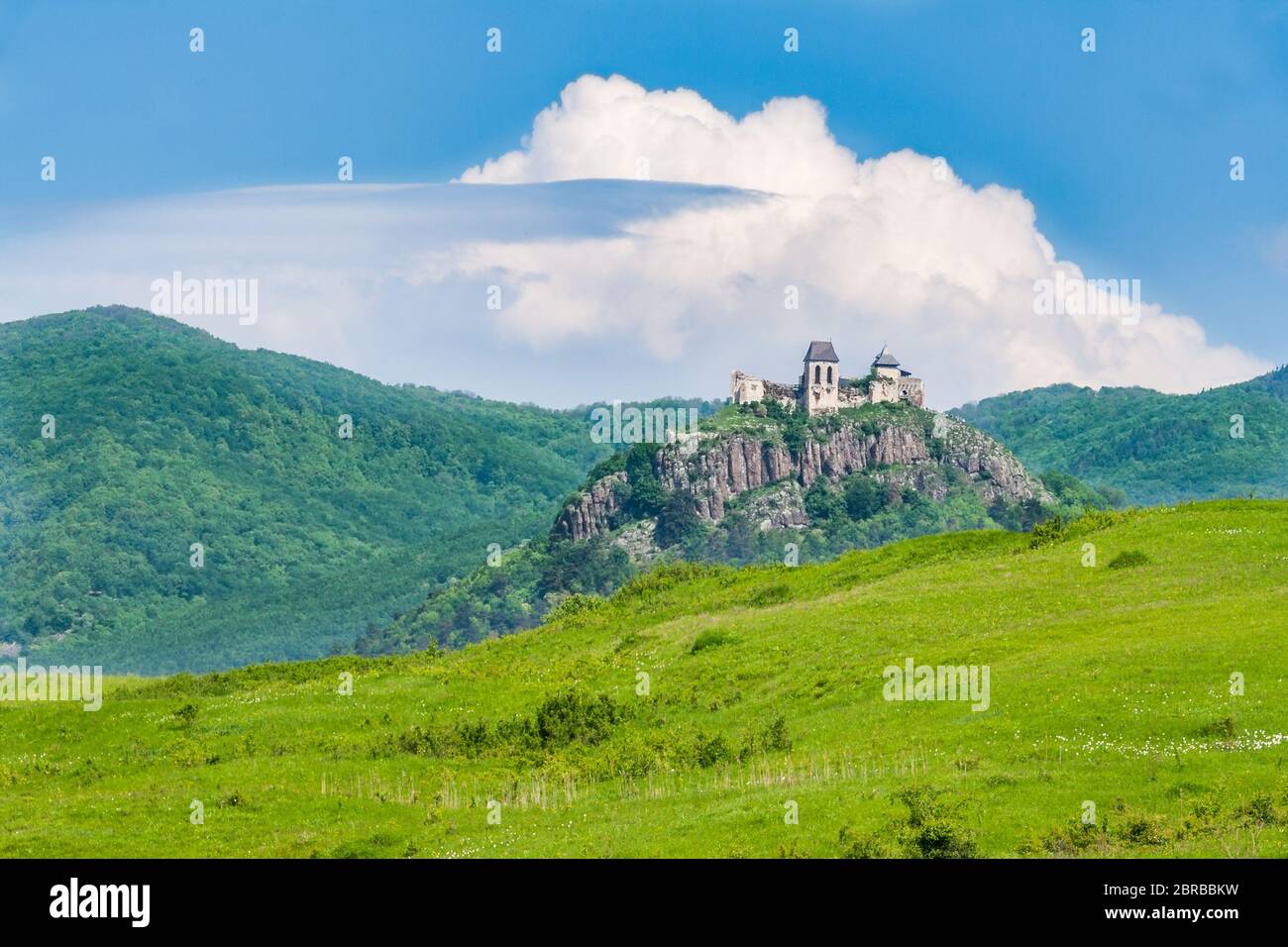 Old castle ruins and mountain background under blue sky and clouds ...