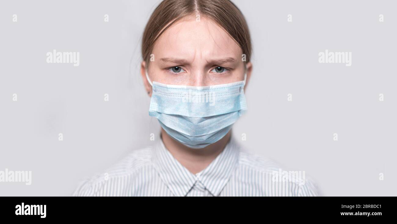 teenager girl 12-13 years old, face covered with medical mask, close-up ...