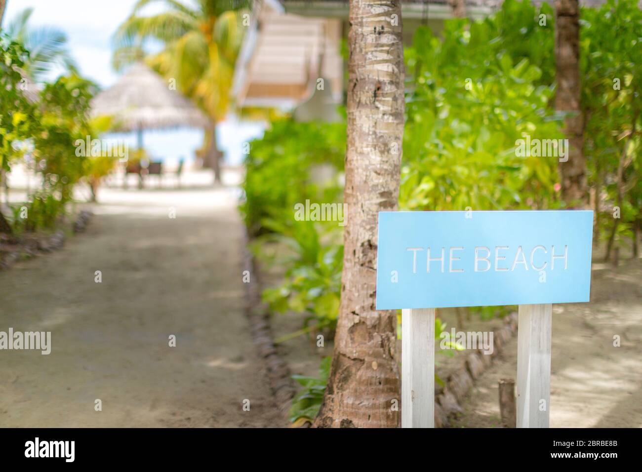 Wooden signboard on tropical beach path to outdoor restaurant and beach ...