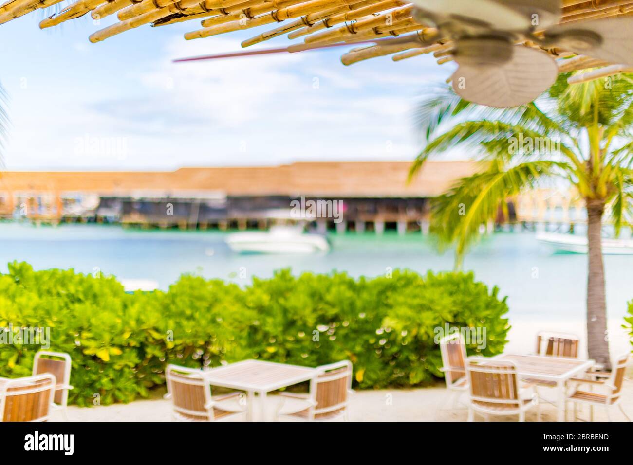 Beach bar view towards, chairs and tables with sea view and speedboat ...