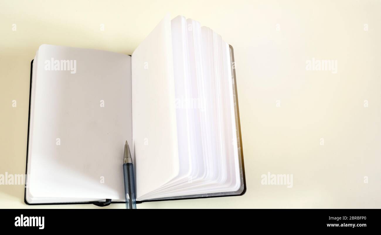 A ballpoint pen in the middle of an open notebook. Unwritten blank ...