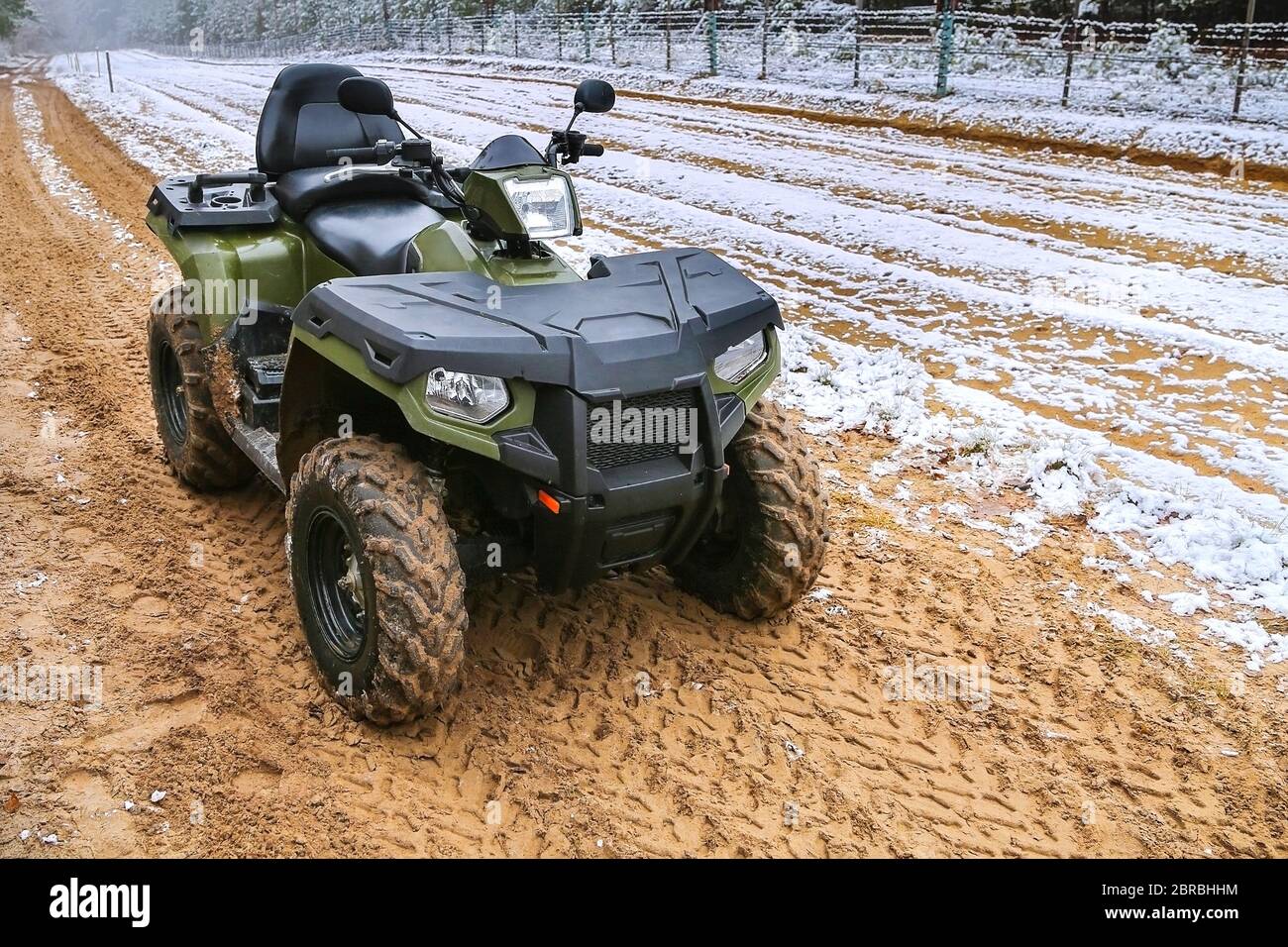 ATV stands on winter background on the state border. Quad bike in the ...