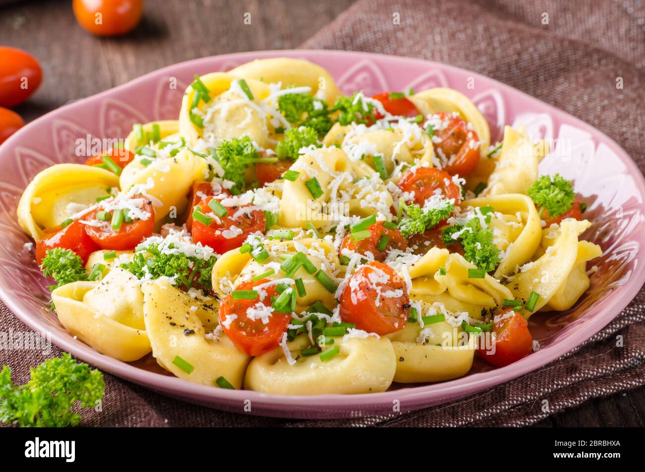 Filled tortellini with herbs, tomatoes, fresh cheese, food photography, product photo Stock ...