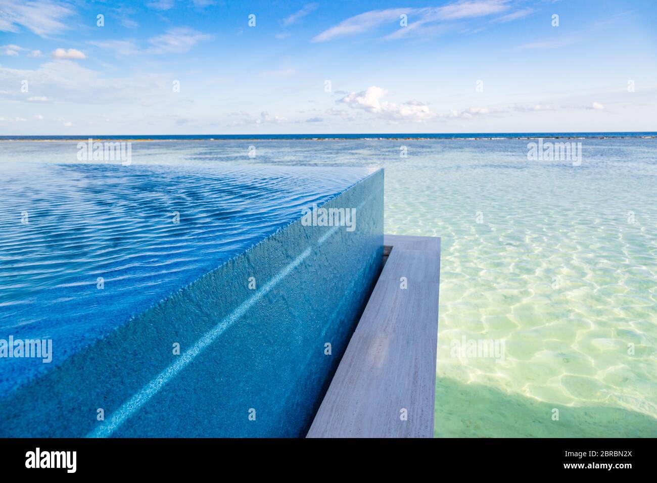 Bokeh light background in the pool. Luxury infinity swimming pool, blue pool closeup as resort ...