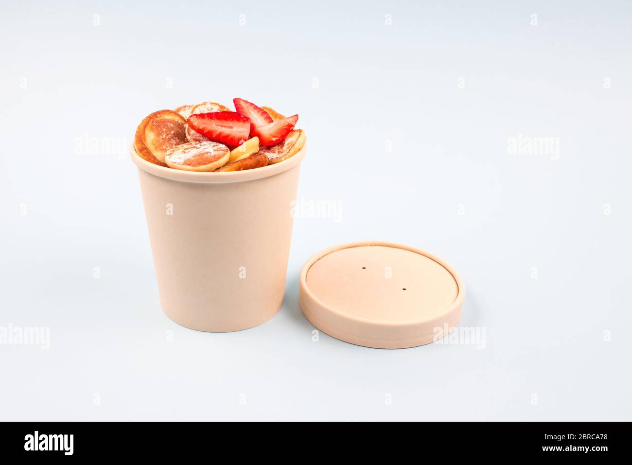 Mini pancakes cereal with strawberries in recyclable paper cup ...