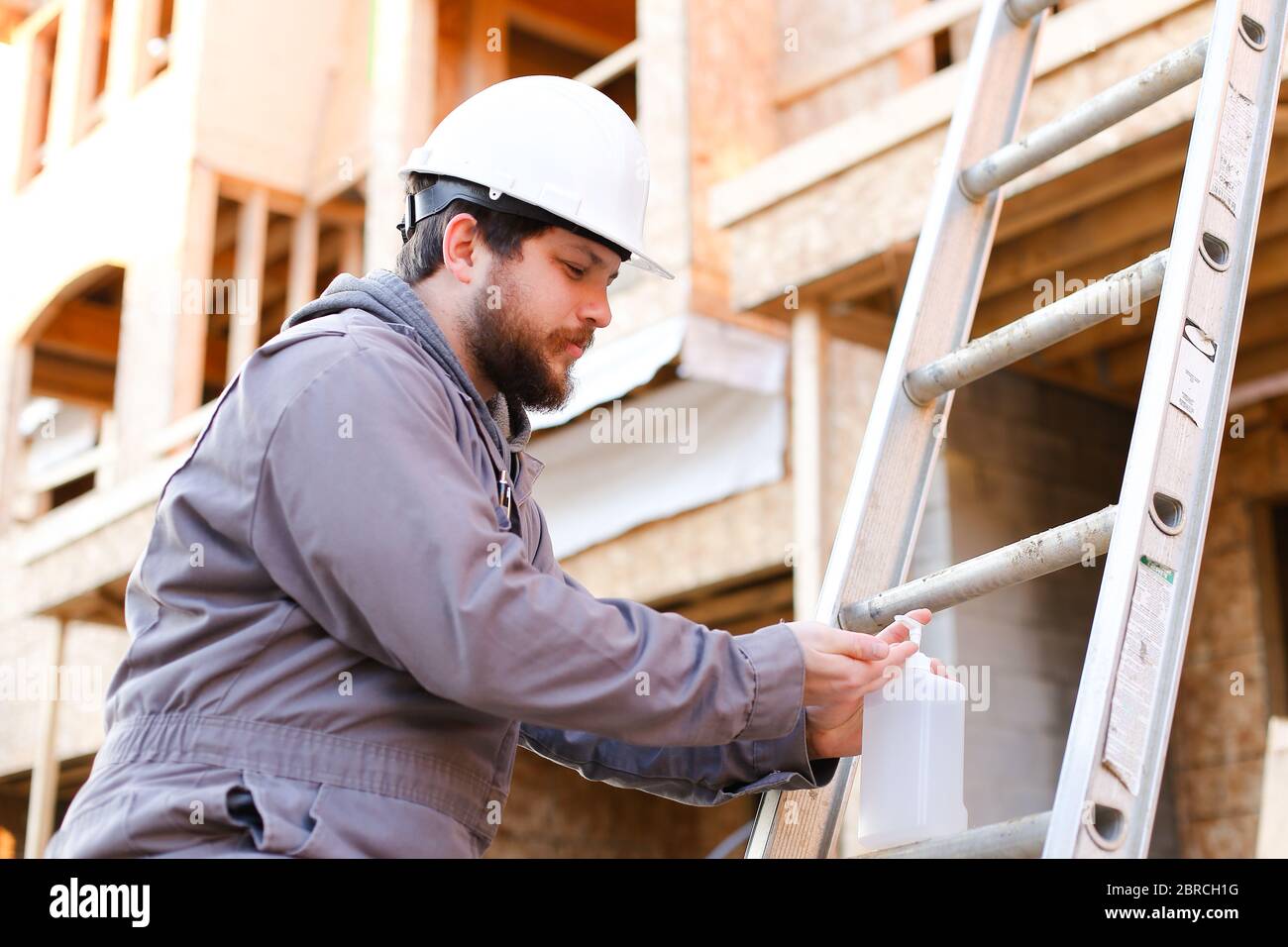 Young engineer using disinfectant soap on construction site Stock Photo ...