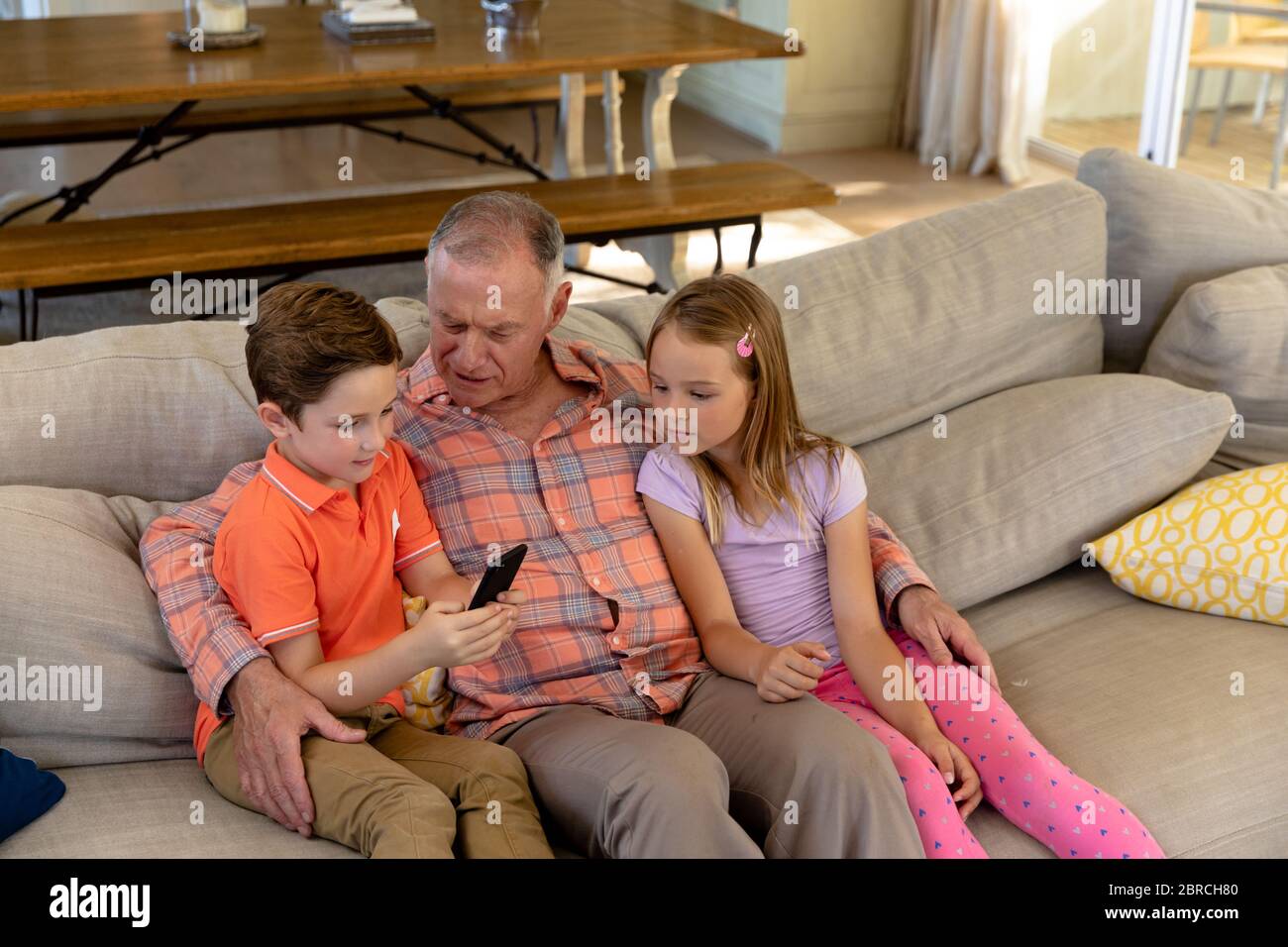 Grandfather and grandchildren at home in the living room Stock Photo ...