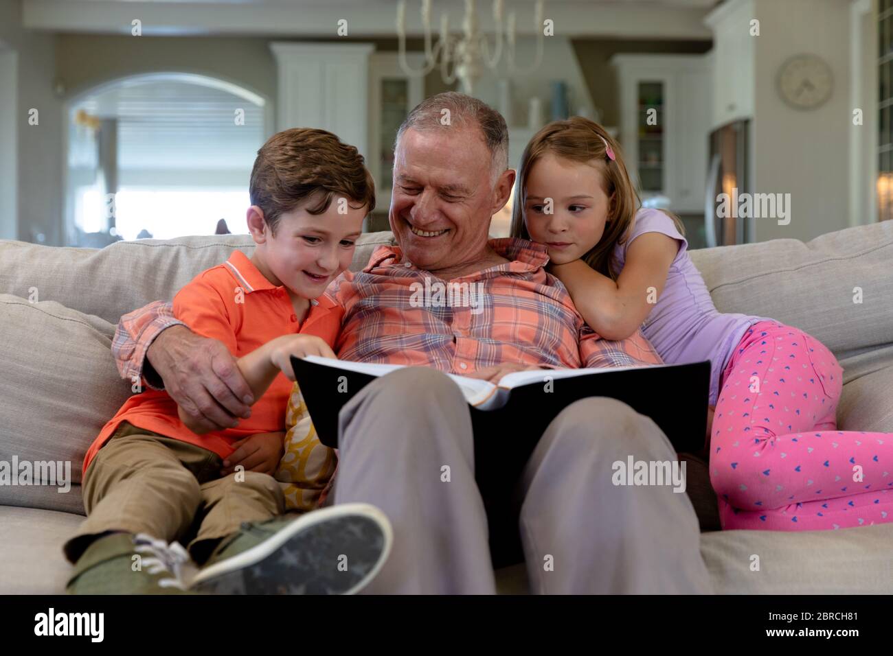 Grandfather and grandchildren at home in the living room Stock Photo ...