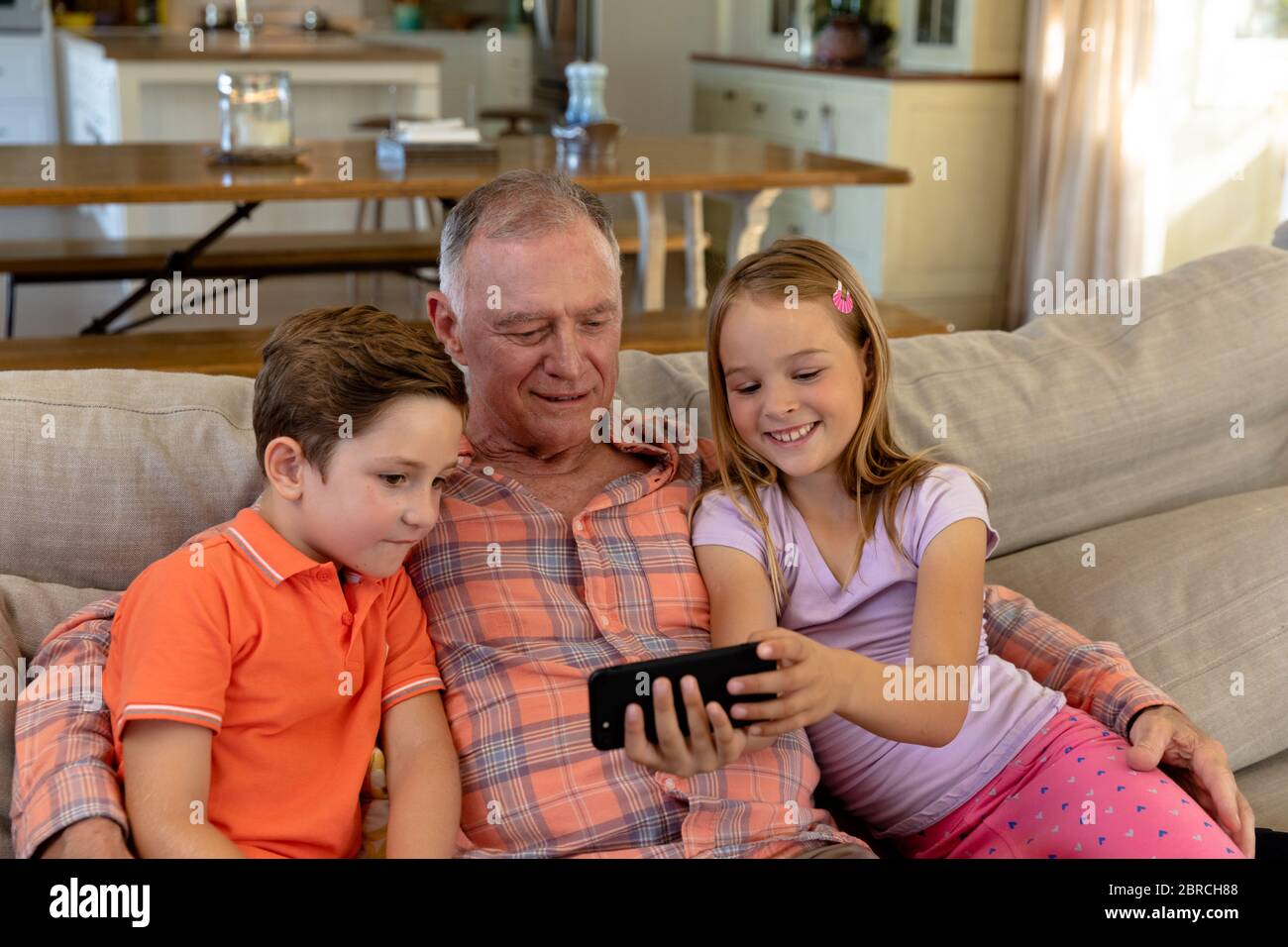 Grandfather and grandchildren at home in the living room Stock Photo ...