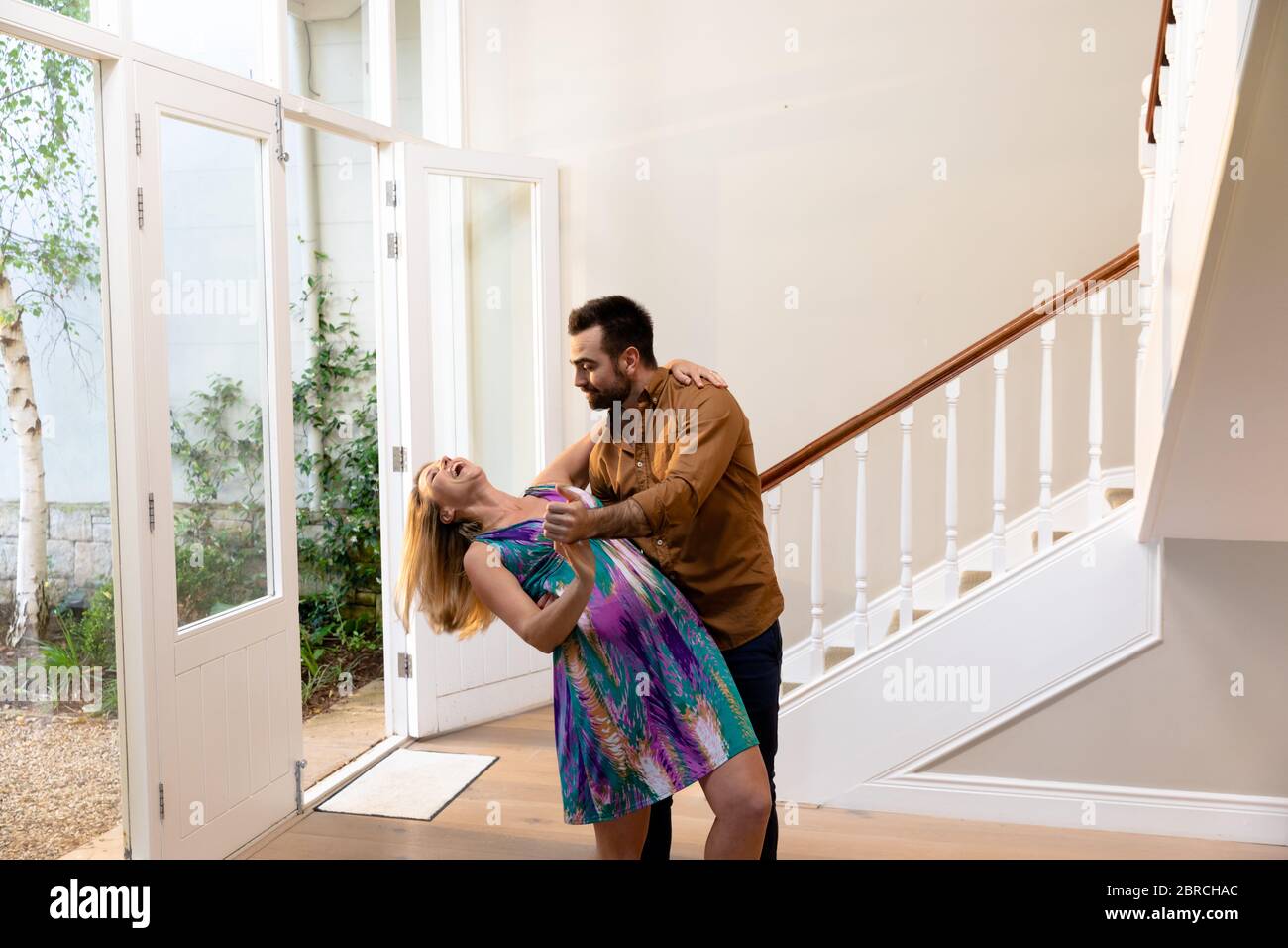 Caucasian couple having fun dancing and smiling in the hallway Stock ...