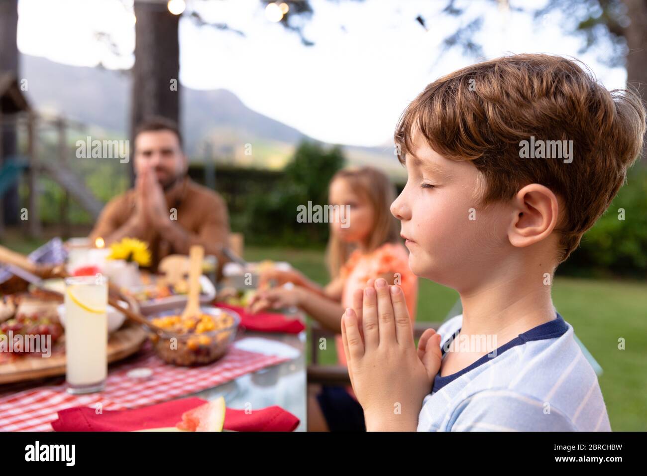Caucasian family saying grace together before eating Stock Photo - Alamy